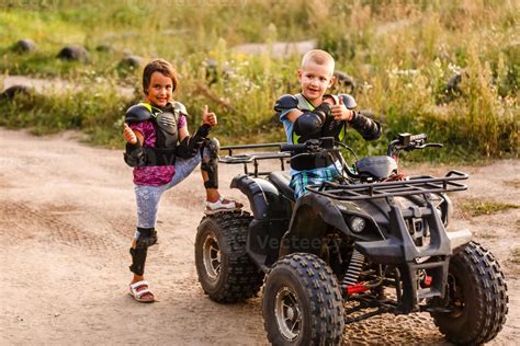 crianças felizes brincando na estrada durante o dia eles dirigindo em quadriciclo no parque