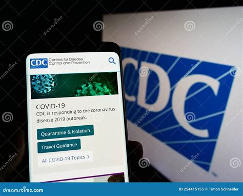 Person Holding Smartphone With Website Of Centers For Disease Control