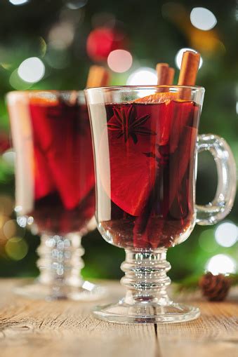 크리스마스의 두 유리 Mulled 와인 또는 Gluhwein 향신료와 오렌지 슬라이스 크리스마스 트리 시골풍 테이블에 겨울