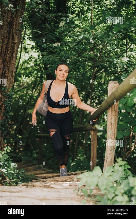 Fit Young Woman Hiking In Forest Climbing Up The Stairs Wearing Black