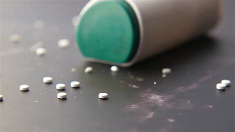 Little Pils Spread Out On Black Surface Container Next To It 13826534