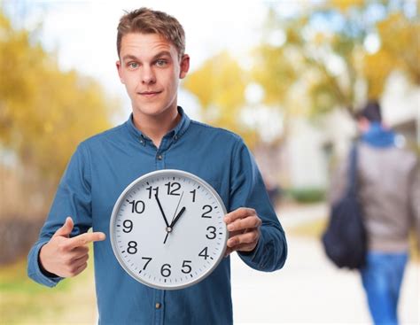 Free Photo Man Pointing To A Big Clock