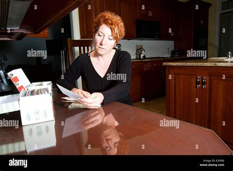 Female Sorting Recipe Cards At A Kitchen Table Stock Photo Alamy