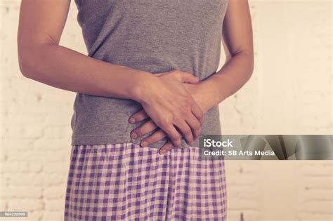 그녀의 배꼽에 손을 잡고 고통 스러운 복 통 데 젊은 여자의 닫습니다 신체 통증 위 염 변 비 생리통과 생리 경련 여성 건강 개념 건강관리와 의술에 대한 스톡 사진 및 기타