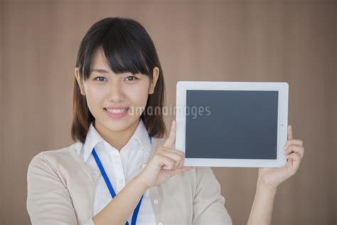 タブレットpcを持ち微笑むビジネスウーマンの写真素材 Fyi04555792 ストックフォトの Qlean Market