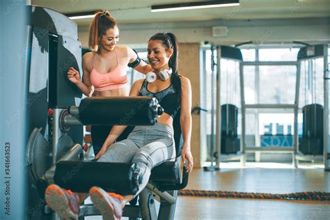 Babe Woman Having Exercises On Leg Extension And Leg Curl Machine In The Gym Stock Photo