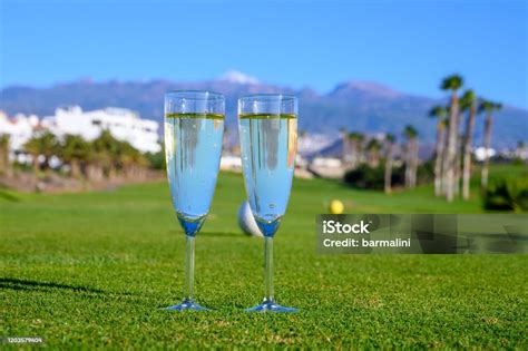 골프 대회 이벤트 또는 축하 기간 동안 산이 보이는 녹색 골프 클럽 잔디에 거품 흰색 샴페인 또는 카바 와인 2 잔 제공 0명에 대한 스톡 사진 및 기타 이미지 Istock