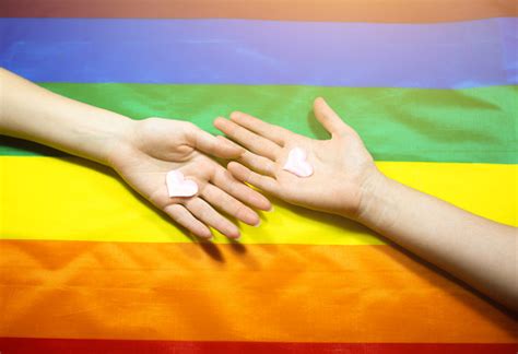 Lgbt 커뮤니티 다채로운 플래그 무지개 배경에 두 여자의 손 레즈비언과 게이 문제 동성애 성향을 가진 커플의 결혼 합법화 Lgbtqia 문화에 대한 스톡 사진 및 기타