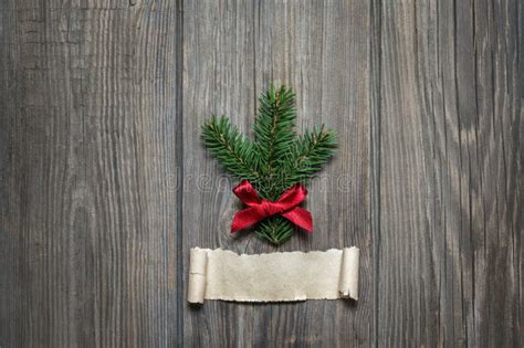 Christmas Tree Made From Spruce Branch With Red Bow On Old Wooden
