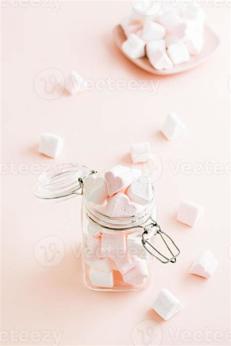 marshmallows brancos e rosa em forma de coração em uma jarra e em um