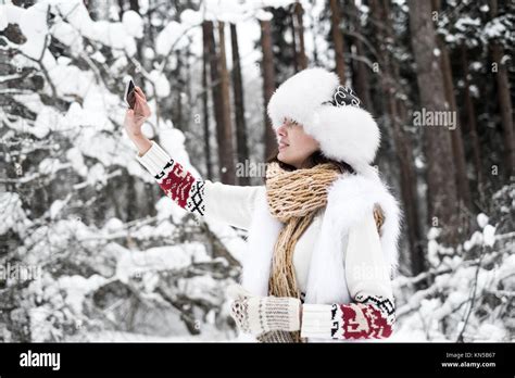 Beautiful Woman Is Taking Selfie Outdoors In A Nature Snowy Trees In