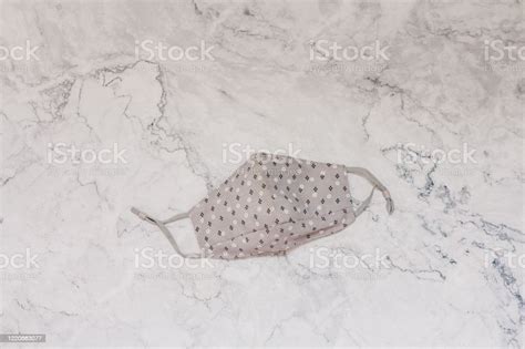 아름 다운 직물 얼굴 마스크입니다 베이 지 내츄럴 한 색상 대리석 배경에 호흡 붕대 얼굴 바이러스 및 전염병