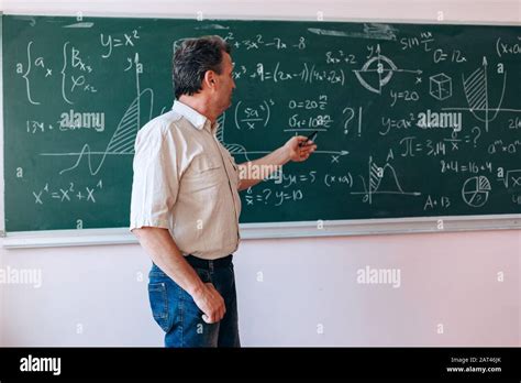 Teacher Pointing To The Blackboard And Explain A Lesson Image Stock Photo Alamy