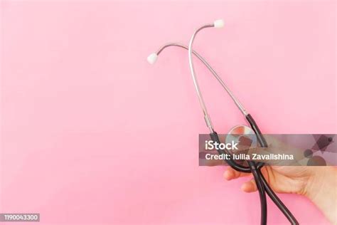 트렌디 한 파스텔 핑크 배경에 고립 된 심플리 미니멀 디자인 여성 손 들고 의학 장비 청진기 또는 전화 경 건강 검진에 대한 스톡 사진 및 기타 이미지 Istock