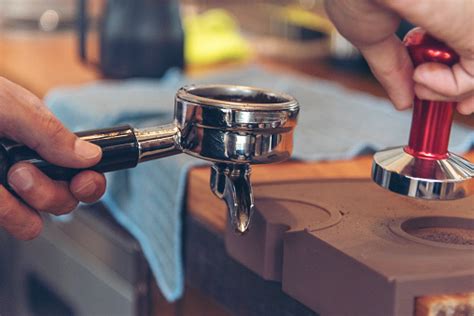 커피 바리스타 커피 메이커 핫컵에서 에스프레소 샷을 만들어보세요 카푸치노와 이탈리아 커피숍 카페 바리스타 사용 기계의 손을 닫는 것은 고객 카페테리아를위한 갈색 라떼 예술을