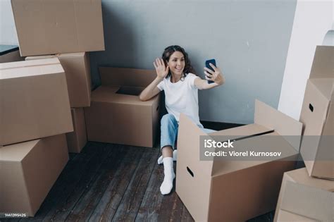 행복한 여자 세입자 집주인이 이사하는 날 판지 상자 근처 바닥에 앉아 화상 통화를 통해 채팅 30 34세에 대한 스톡 사진 및