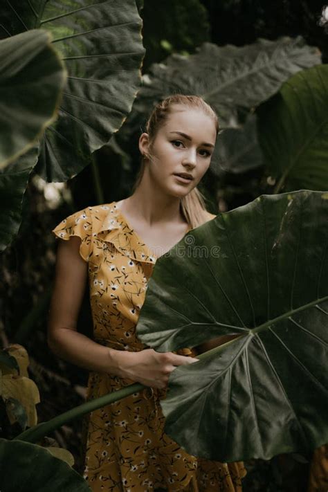 Beautiful Woman Hiding Behind The Palm Leaves In The In The Tropical