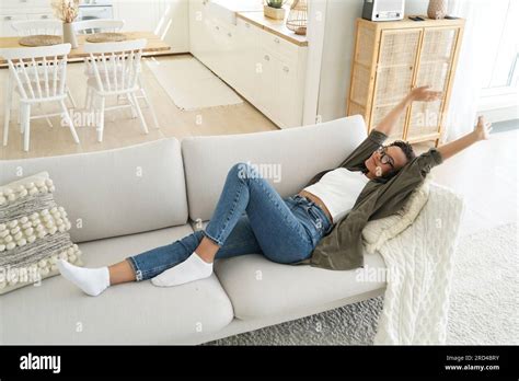 Pleased African American Girl Stretching On A Comfortable Sofa At Home