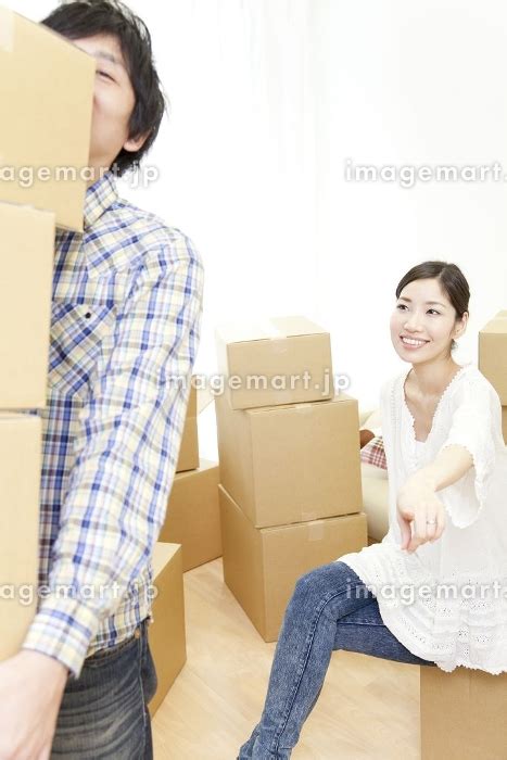 段ボールを運ぶ男性と指示する女性の写真素材 23996791 イメージマート