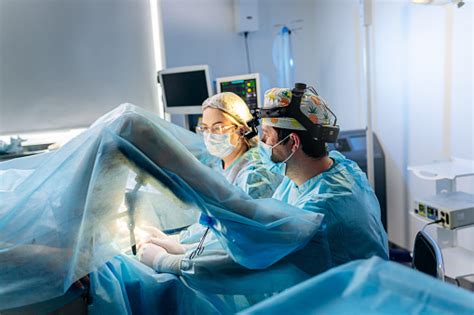 병원의 수술실에서 특수 의료 기기를 사용하여 수술을 수행하는 외과 전문의의 전문 팀 긴급 수술 개념 3 명에 대한 스톡 사진 및
