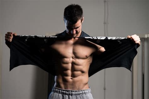 Hombre Guapo De Pie Fuerte En El Gimnasio Y Rasgando La Camiseta Del