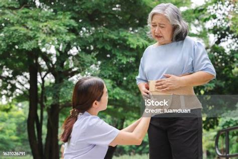 노인들이 등 근육을 위한 등받이를 착용하도록 돕는 간호사 2명에 대한 스톡 사진 및 기타 이미지 2명 건강관리와 의술