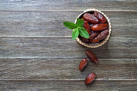 햇볕에 말린 과일과 신선한 민트 잎은 나무 테이블에 세라믹 그릇에 넣습니다 유기농 말린 과일 공간을 복사합니다 맨 위 보기입니다 플랫 레이 갈색에 대한 스톡 사진 및 기타