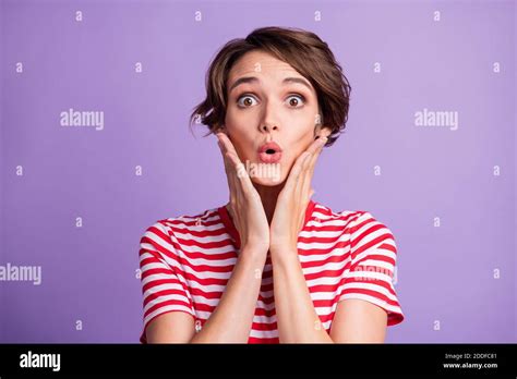 Photo Of Charming Young Girl Shocked Expression Arms Cheeks Wear