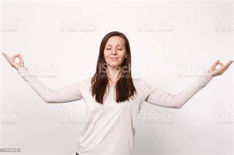 눈을 감고 가벼운 옷에 편안한 젊은 여자 요가 제스처에 손을 잡고 명상 흰색 배경에 고립 된 휴식 사람들은 진심으로 감정 라이프