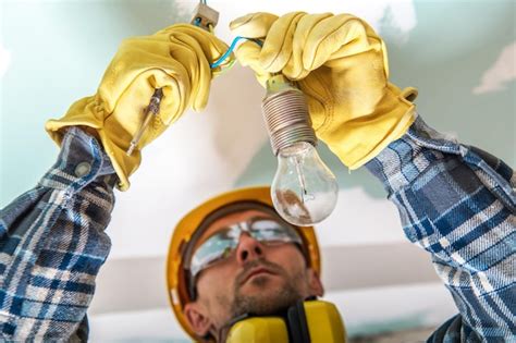 Premium Photo Electrician Checking Cables In A Lighting System To Fix