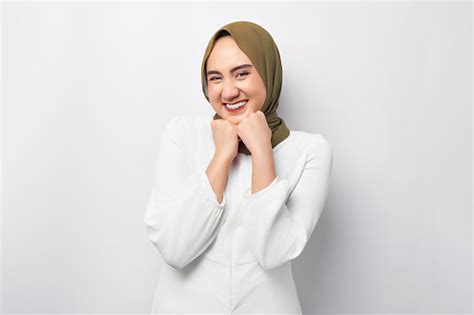 미소는 히잡을 쓴 20대 젊은 아름다운 아시아 무슬림 여성이 턱에 손을 얹고 흰색 배경에 고립된 카메라를 바라보며 만족스럽게 웃고 있다 사람들의 종교적 생활 방식 개념 20