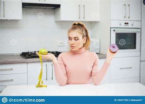 Concepto De Dieta Mujer Joven Que Elige Entre Las Frutas Y Los Dulces