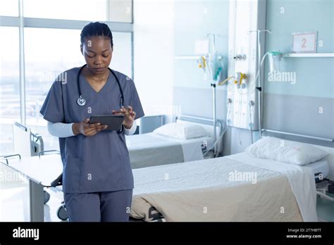 African American Female Doctor Using Tablet In Hospital Room Stock