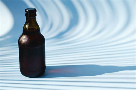 유리 갈색 맥주병의 상위 뷰 파란색 배경에 대한 맥주 한 잔이 닫힙니다 음식 라이프 스타일 알코올 음료 생산 공간을 복사합니다