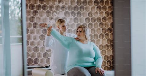 재활 센터에서 실내에서 과체중 여성과 함께 운동하는 중년 물리 치료사 여성 사진 Unsplash의 플러스 사이즈 이미지