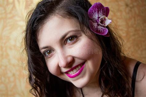 Portrait Of Young Brunette Girl With Orchid Flower In Her Hair Stock
