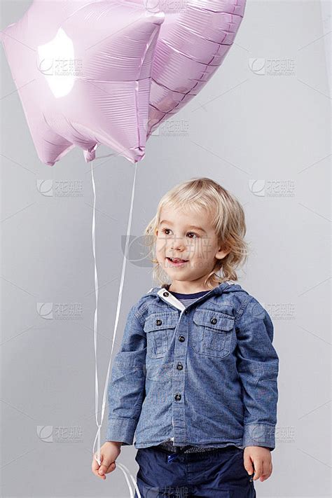 可爱的金发男孩玩气球。