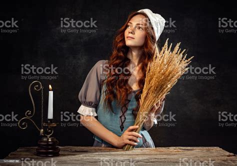 어두운 배경에 고립 된 르네상스 스타일의 드레스에서 중세 인물의 이미지에 긴 곱슬 머리를 가진 젊은 아름다운 빨간 머리 소녀의 창조적 인 초상화 드레스에 대한 스톡 사진 및