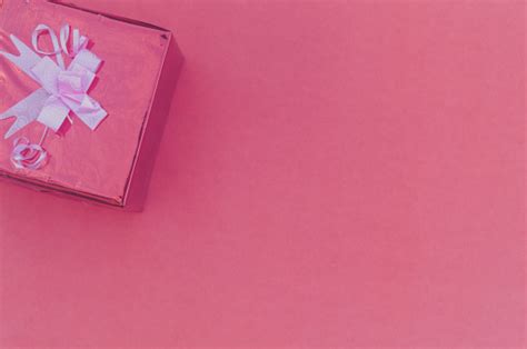 선물 상자는 리본으로 활을 묶고 빨간색 배경의 테이블에 포장지로 감쌌습니다 플랫 레이 맨 위 보기 발렌타인 데이 기념일 또는 휴일 축하 장식을위한 디자인 텍스트공간을