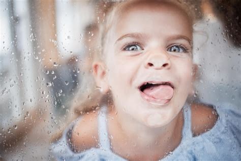 Niño Divertido Y Lengua En El Retrato De La Ventana Con La Cara Tonta Y