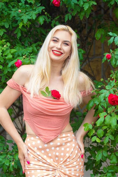 Beautiful Woman With Long Blonde Hair And Red Lips Wearing Pink Clothes