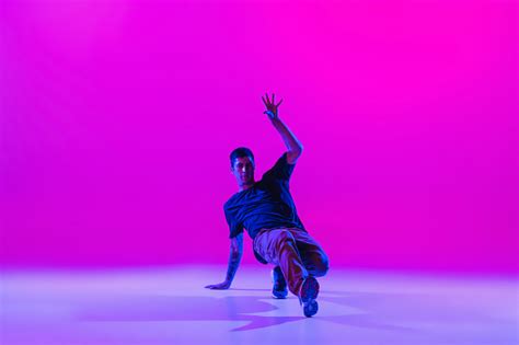 네온 빛의 댄스 홀에서 밝은 마젠타 배경위에 고립 된 현대 의류에서 솔로 춤을 추는 젊은 세련된 남자 힙합 댄서 거리에 대한 스톡 사진 및 기타 이미지 Istock