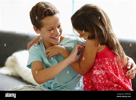 Tickle Fight A Brother And Sister Tickling Each Other While On The Sofa Stock Photo Alamy
