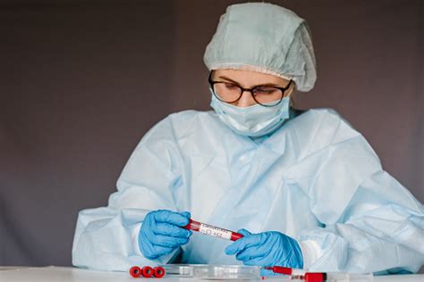 호흡기 마스크에 간호사혈액 검사를 들고 긍정적 인 결과 빠르게 확산 코로나 바이러스 2019ncov에 대한 샘플 혈액 튜브