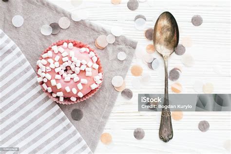 뿌리와 마 시 멜로와 맛 있는 화려한 핑크 도넛 색종이와 빈티지 숟가락 평평한 누워와 세련 된 흰색 테이블에 있습니다 파티