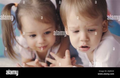 Brother With Sister Under 3 Years Watching Cartoons Lying On His