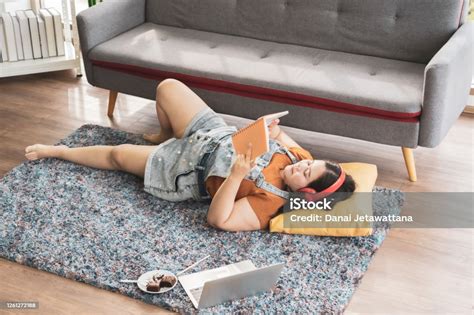 플러스 크기 여자 헤드폰 에 컴퓨터 노트북 카펫 독서 책에 누워 집에서 작업 과체중에 대한 스톡 사진 및 기타 이미지 과체중