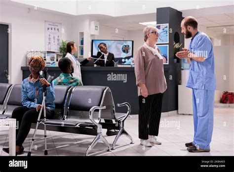 Elderly Woman Receiving Instructions From General Practitioner In Hospital Waiting Room African