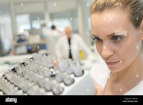 Female Scientist Examining Chemical Sample In Test Tube In Lab Stock