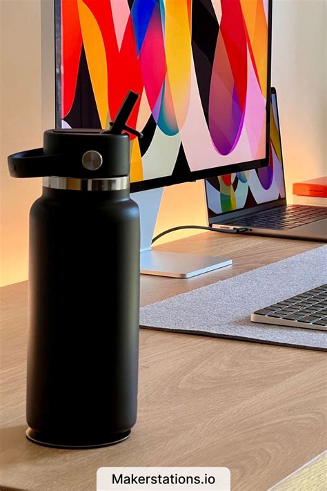 An Apple Studio Display And A Water Bottle In A Minimalist Home Office